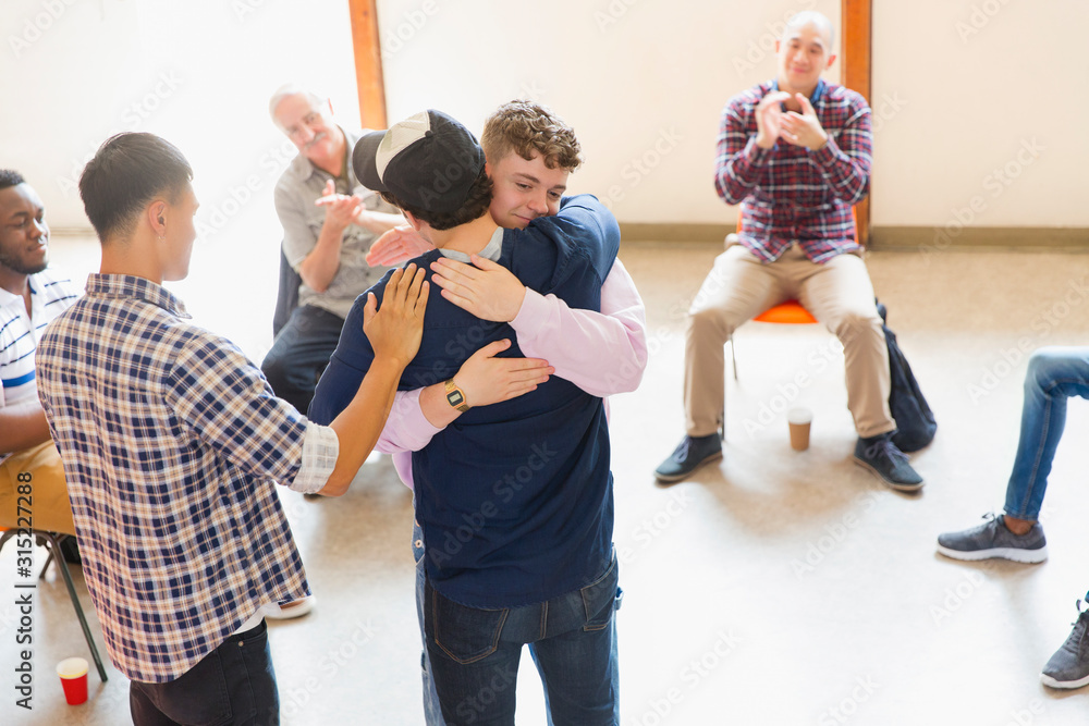 Men hugging and clapping in group therapy Stock Photo | Adobe Stock