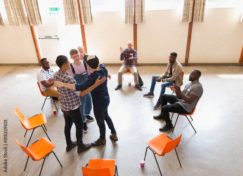 Men hugging and clapping in group therapy Stock Photo | Adobe Stock