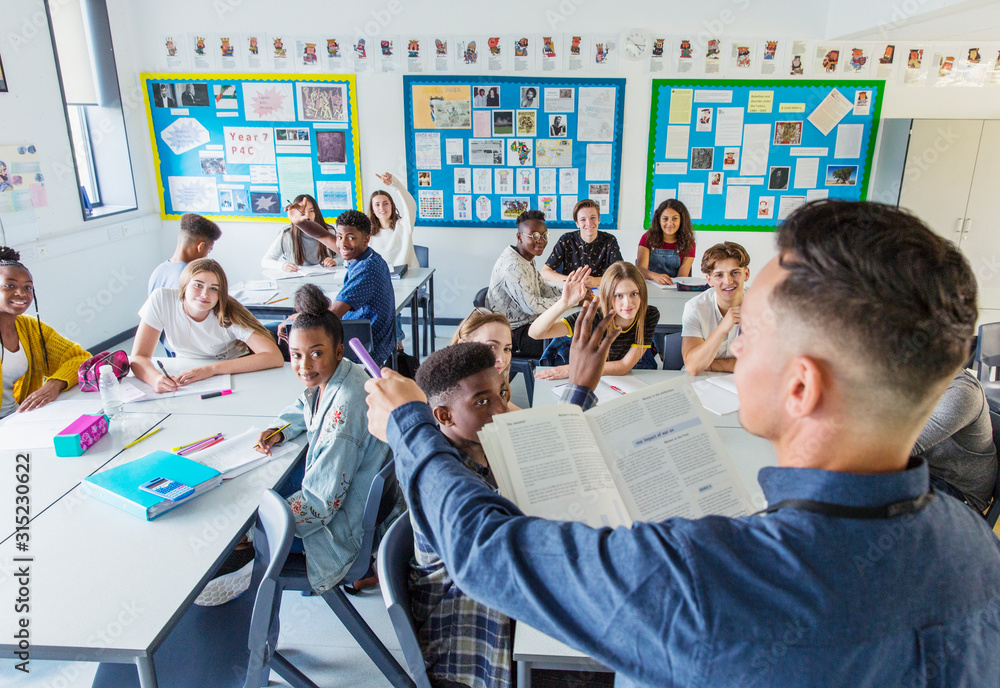 High school teacher calling on students during lesson in classroom ...
