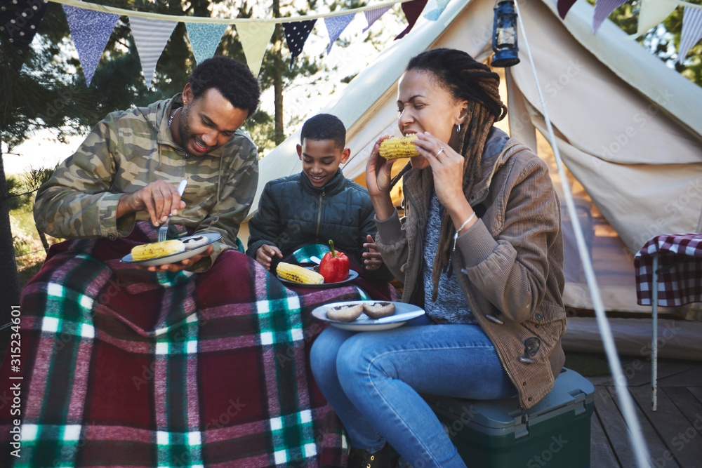 Family eating corn on the cob at campsite Stock Photo | Adobe Stock
