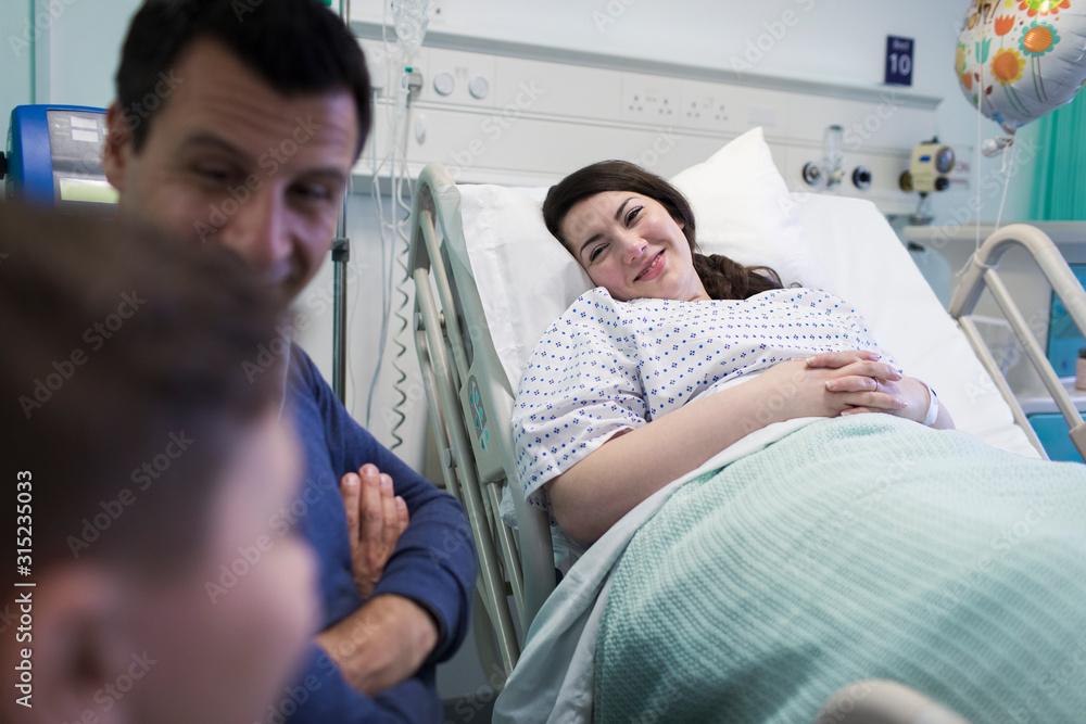 Smiling patient visiting with family in hospital room Stock Photo ...