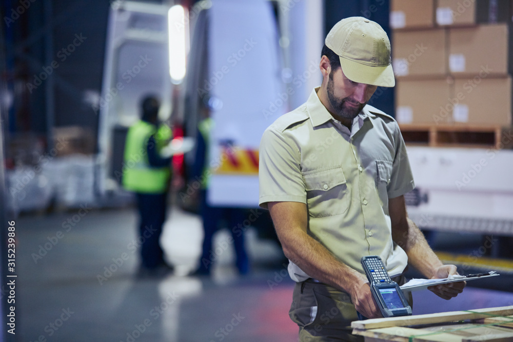 Truck driver worker scanning pallet at distribution warehouse loading ...