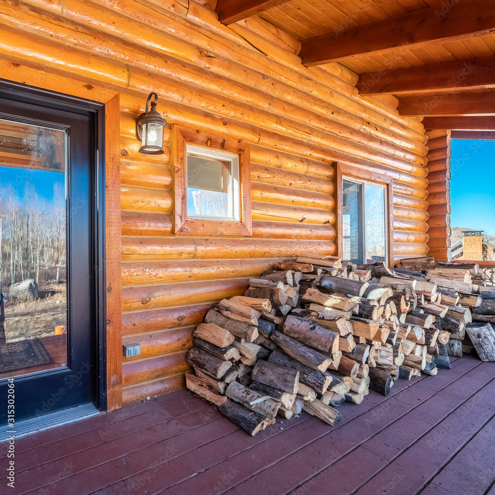 Square Log cabin with stacked firewood on the porch Stock Photo | Adobe ...