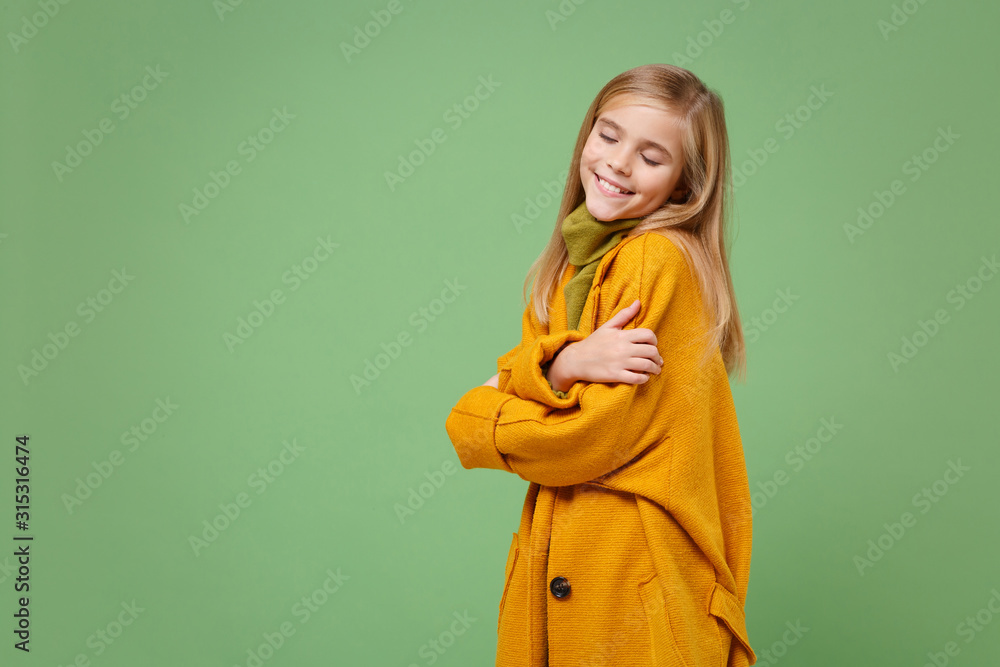 Pretty little blonde kid girl 12-13 years old in yellow coat isolated ...