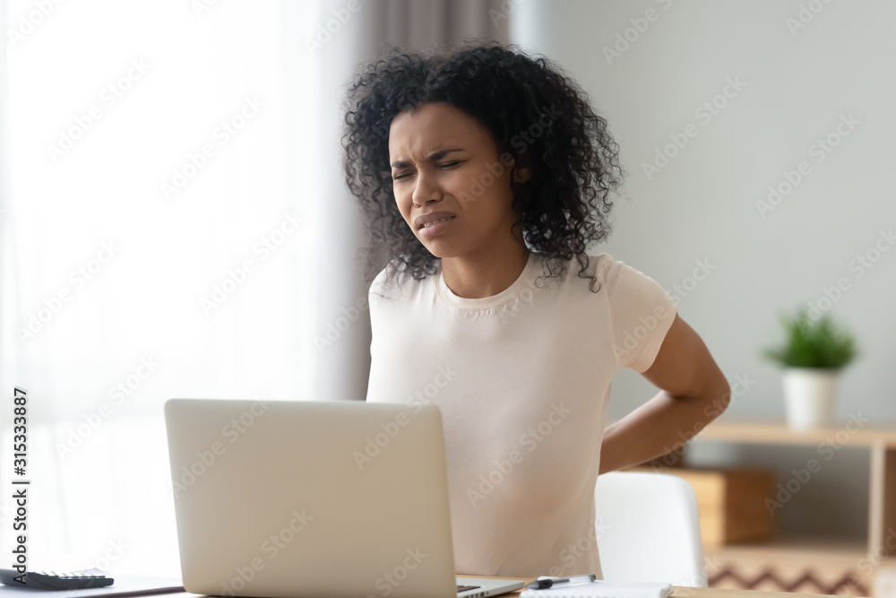 African woman after laptop long usage having lower back pain Stock ...