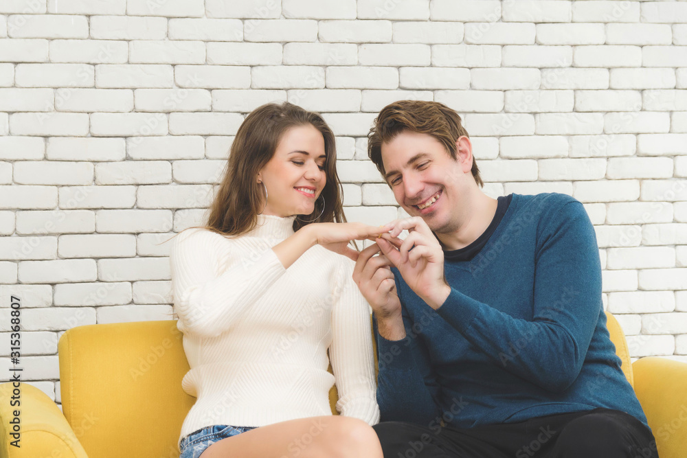 Couple hugging and holding hands while looks an engagement ring. Stock ...
