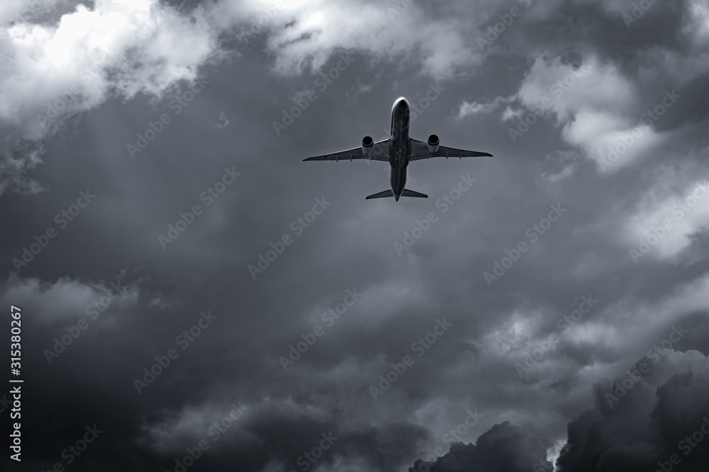 Airplane flying on dark sky and white clouds. Commercial airline with ...