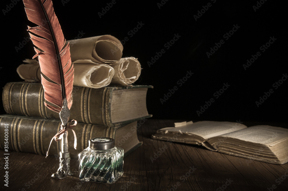 Quill pen and rolled up papyrus sheets with old books, vintage effect ...
