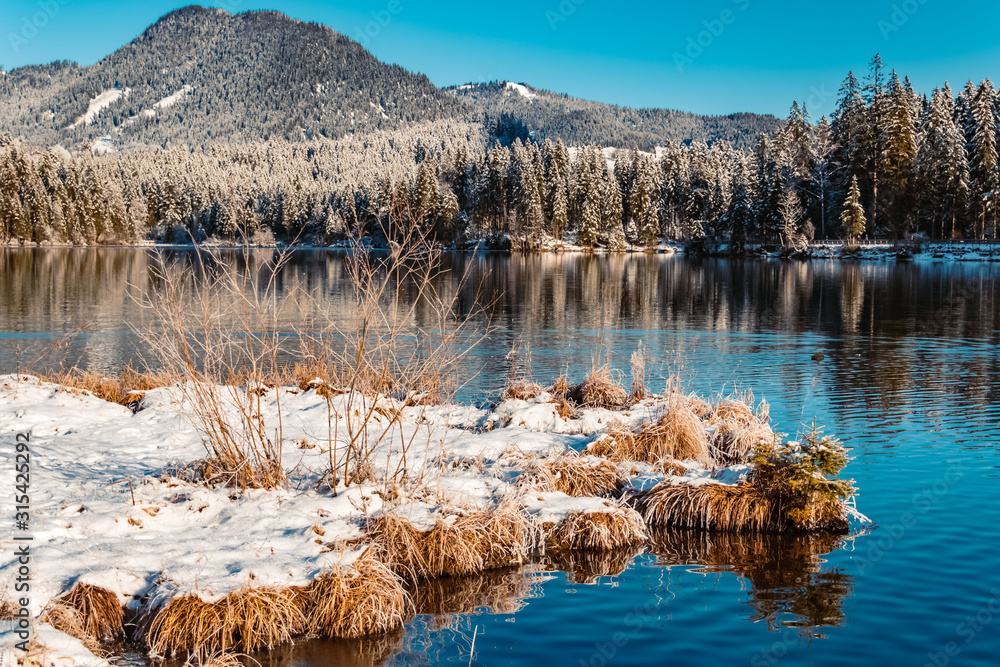 Beautiful winter landscape with reflections at the famous Hintersee ...