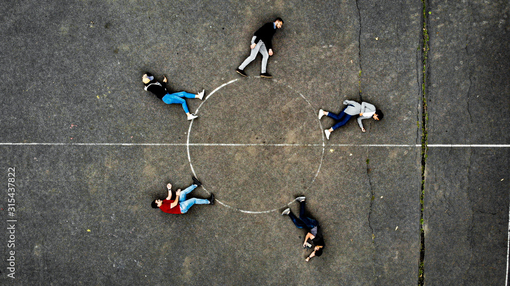 Personas caminando sobre un circulo en el piso siguiendo entre ellas ...