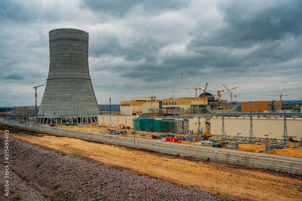 Construction site of new nuclear power plant on cloudy sky background ...