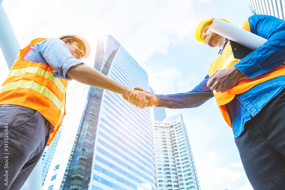 Engineer men making handshake in the city, high building background ...