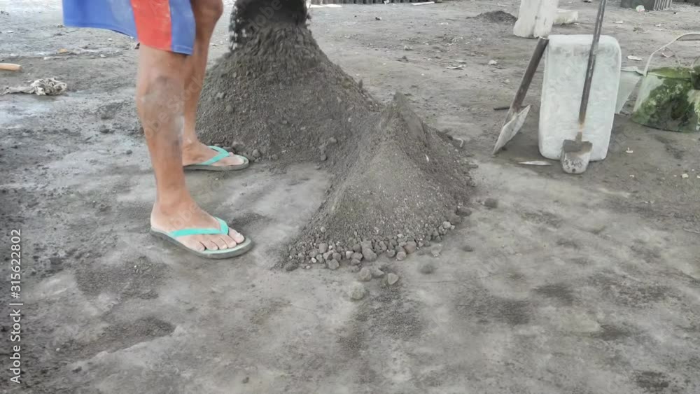 the stages of the brick making process, stirring sand and black cement ...