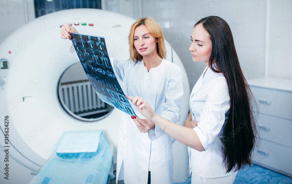 Two beautiful model girls doctors examine CT Scan picture Stock Photo ...