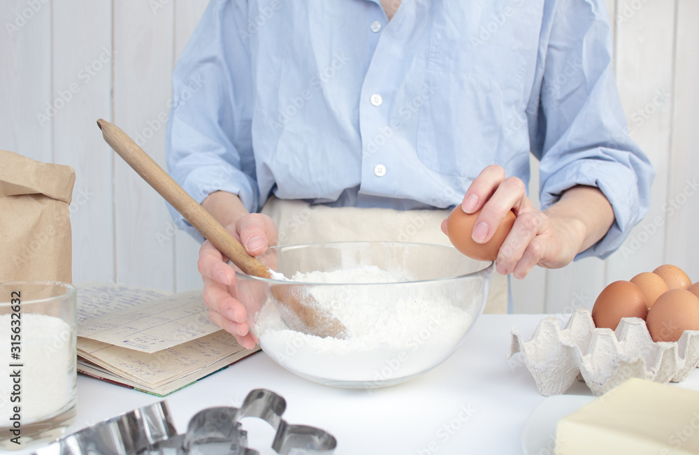 cropped image of woman cooking a cake with recipe, homemade cookies in ...