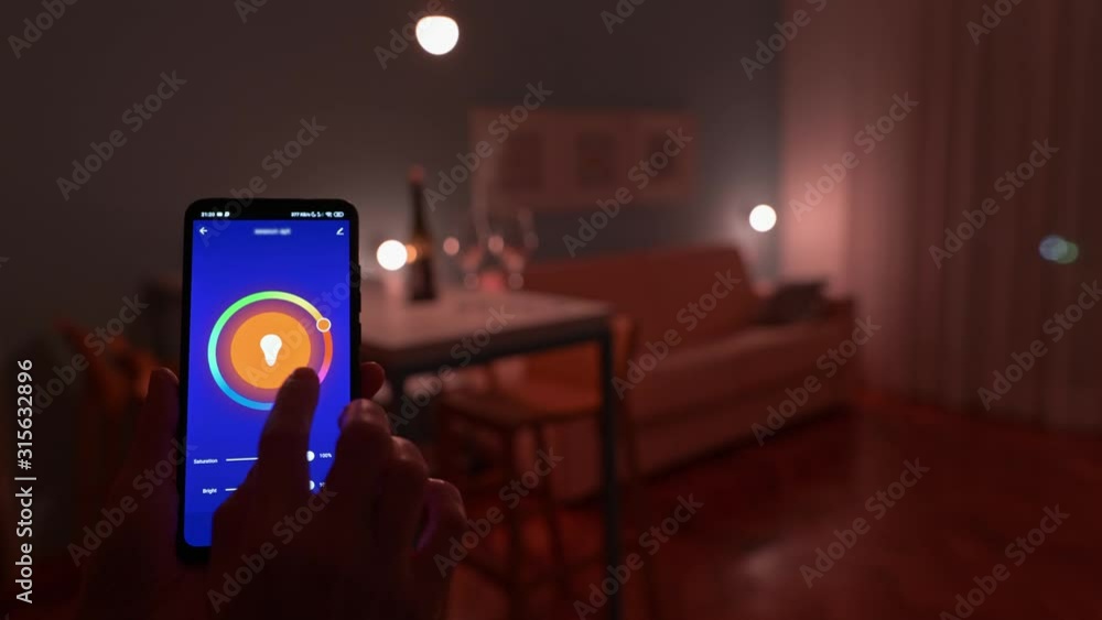 Smart home concept. Woman turning on light in room and changing color ...