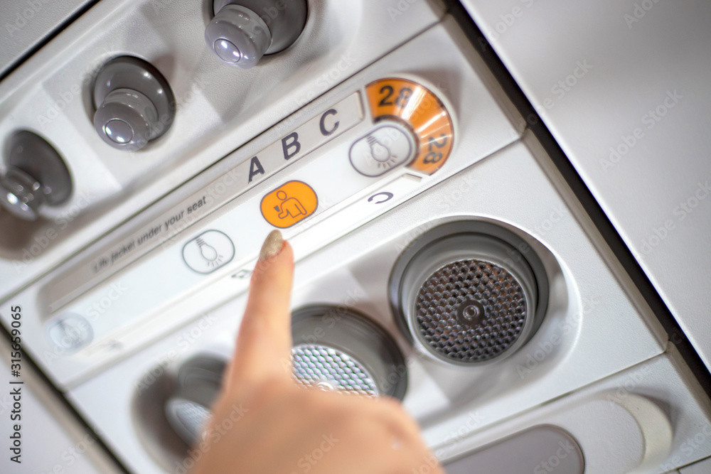 Female finger over flight attendant call button on airplane foto de ...