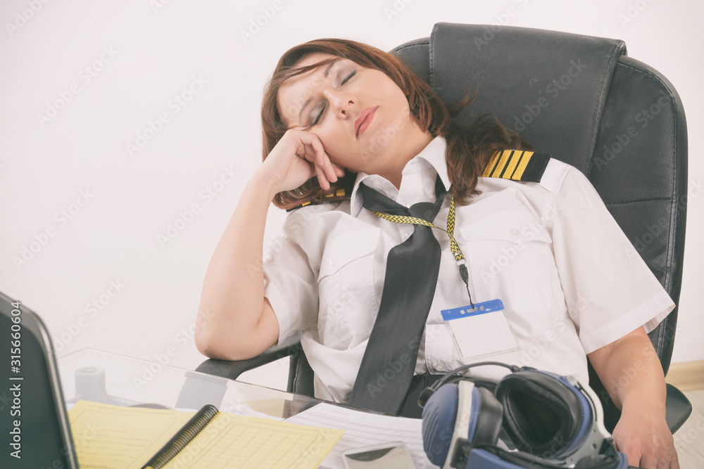 Woman airline pilot sleeping in the office Stock Photo | Adobe Stock