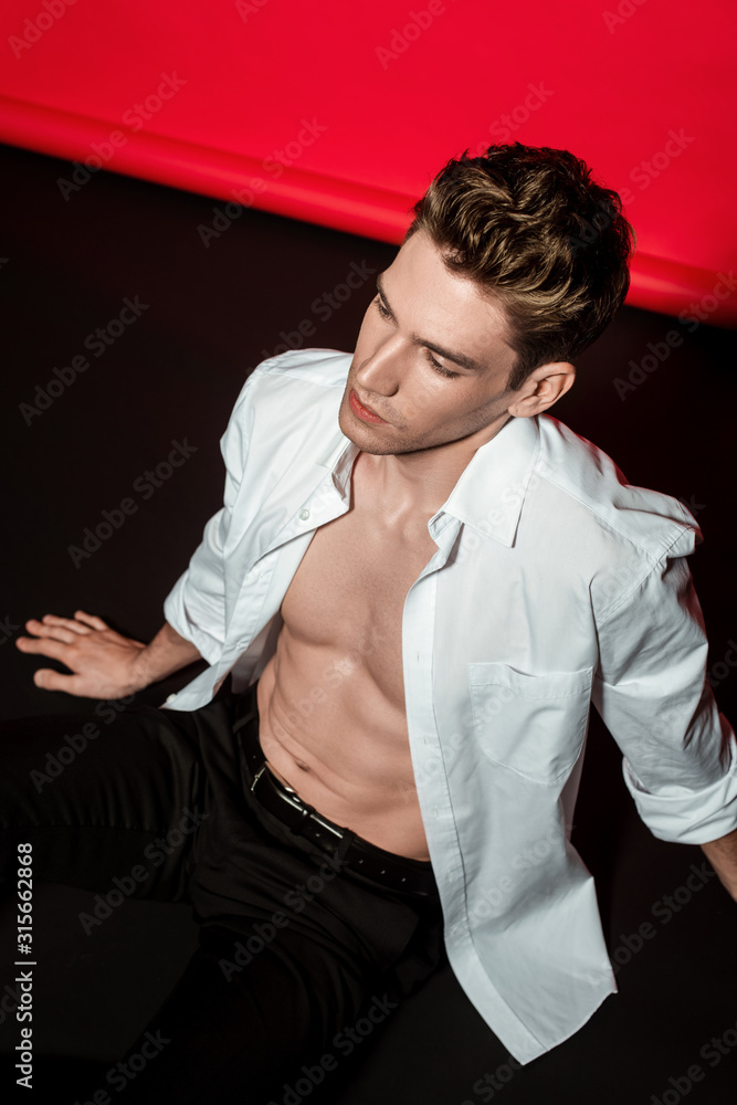 sexy young elegant man in unbuttoned shirt with muscular bare torso ...