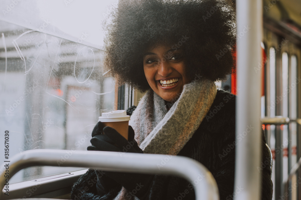 Beautiful girl with afro haircut portraits in the public transport ...