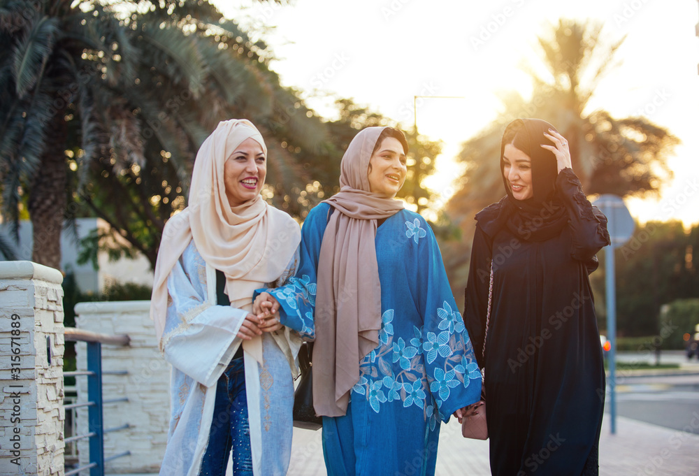 Three women friends going out in Dubai. Girls wearing the united arab ...