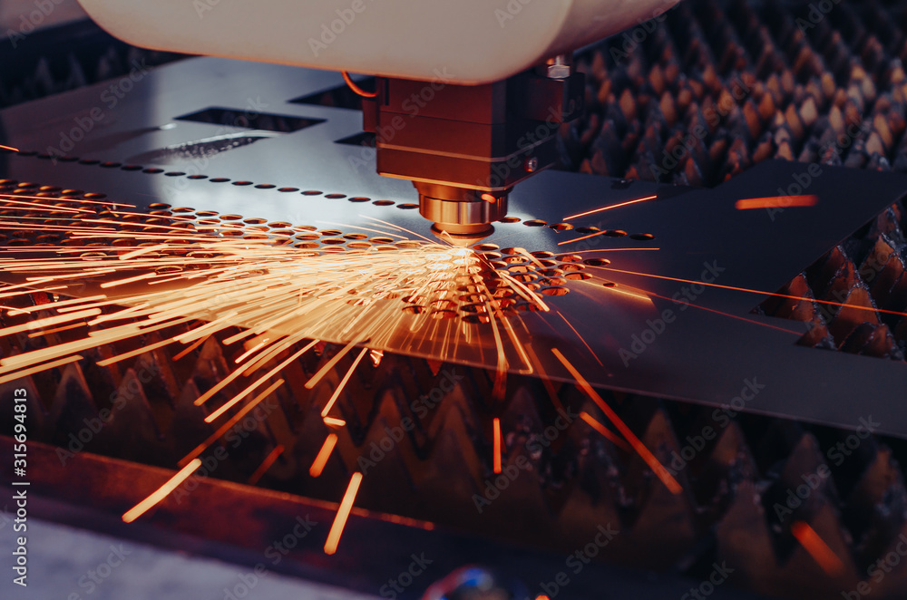 Machine for laser cutting of metal. Laser head cuts the sheet with a ...