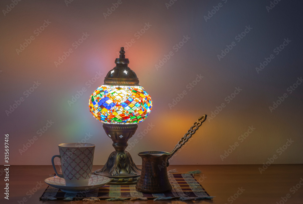 Turkish coffee in cezve, Turk and a traditional old Arabic lamp glows ...