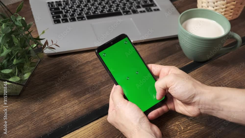 man holding a smartphone in the hands of a green screen green screen ...