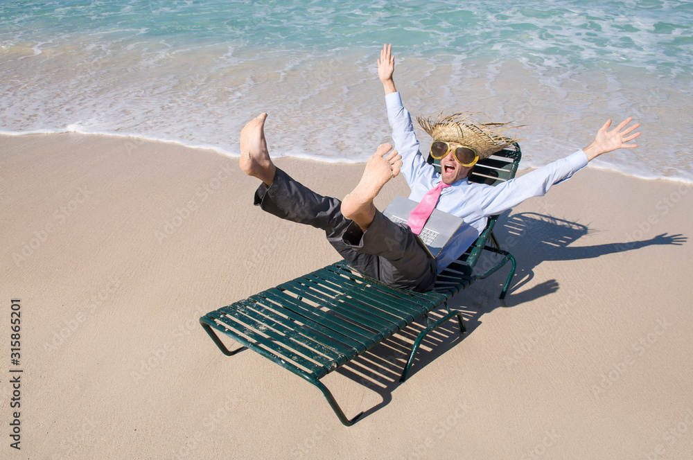 Excited businessman kicking up his bare feet and throwing out his hands ...