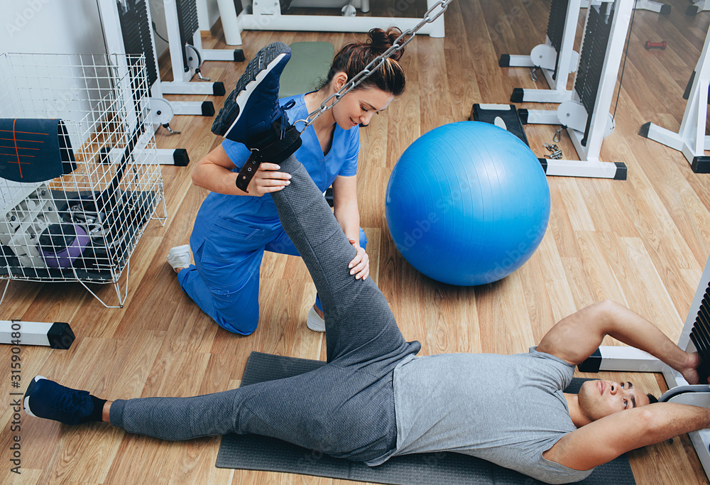 Kinesitherapist treats athlete's foot injuries after hard training. Knee pain. Kinesitherapy ...