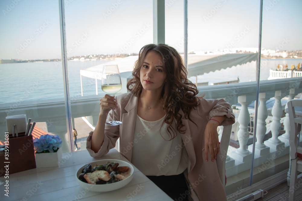 Adult beautiful woman sit in elite restaurant with a beautiful view of ...