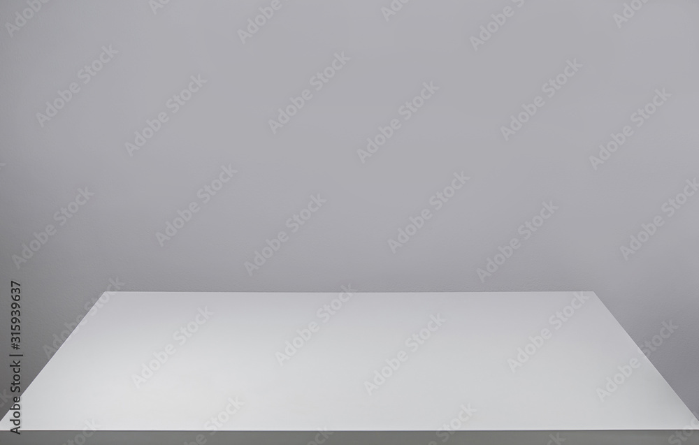 Empty white desk table and a blank grey wall for copy space. Graphic ...