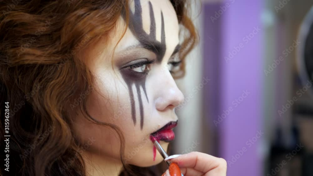 Easy Halloween Makeup. Applying makeup to the face. Drawing red blood ...