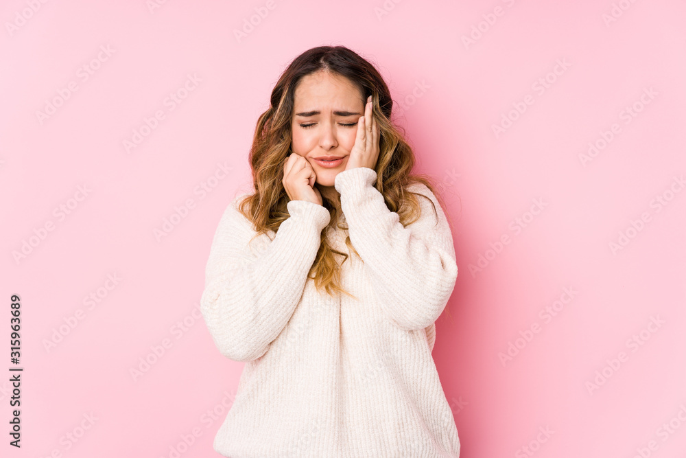 Young curvy woman posing in a pink background isolated whining and ...