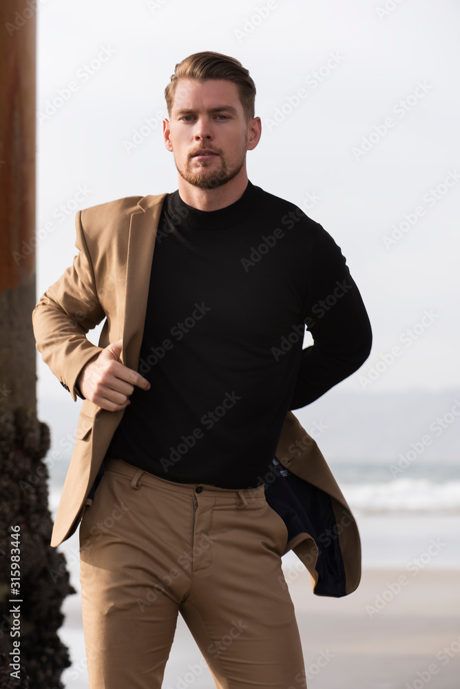 Foto de Handsome man putting on a suit jacket outdoors do Stock | Adobe ...