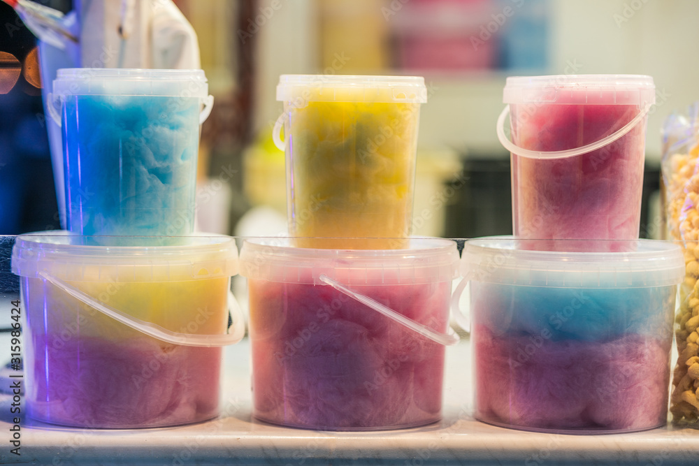 buckets filled with cotton candy of different colors in amusement park ...