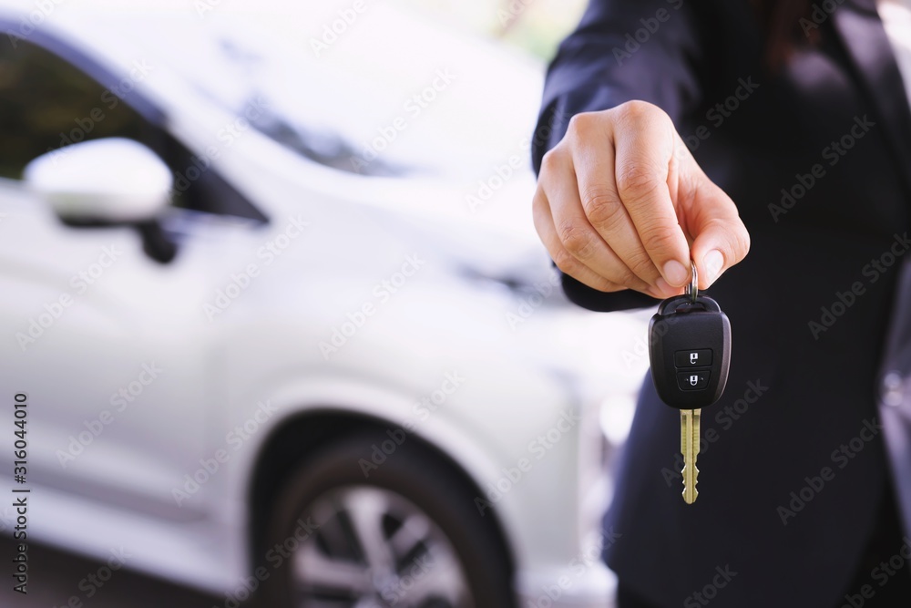 The male salesperson delivers the new car key back to the customer at ...