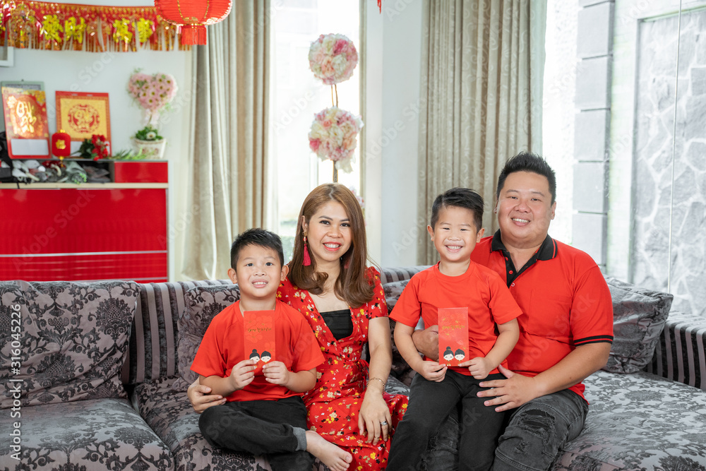 Asian family with two son holding ang pao smiling looking at camera ...