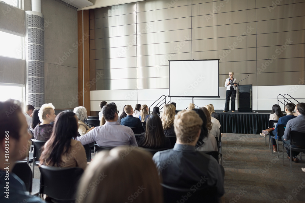 Students in auditorium audience watching professor on stage Stock Photo ...
