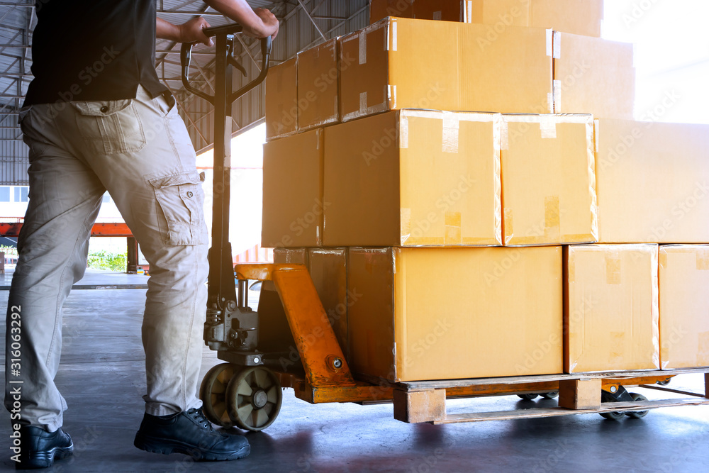 Workers Unloading Packaging Boxes on Pallets in The Warehouse. Cartons ...
