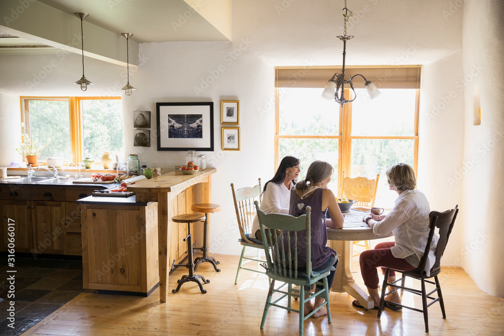 Women talking and drinking coffee at dining table Stock Photo | Adobe Stock