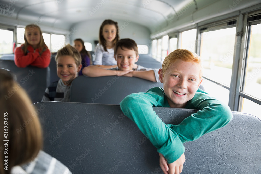 Portrait confident school kids on school bus Stock Photo | Adobe Stock