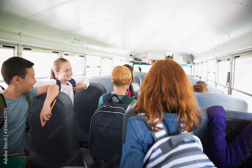 School kids with backpacks in aisle school bus Stock Photo | Adobe Stock