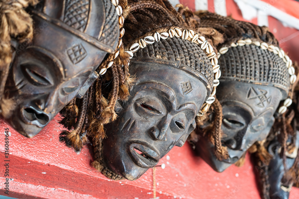 Traditional african wooden masks hanging for sell on the street market ...