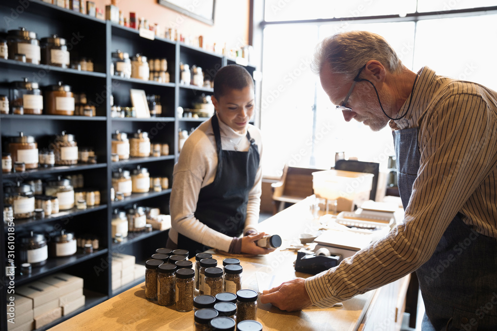 Spice shop owners working at counter taking inventory Stock Photo ...