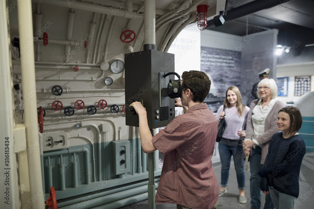 Foto de Boy using Naval periscope at interactive exhibit in war museum ...
