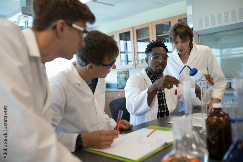 Professor and college students conducting scientific experiment in ...
