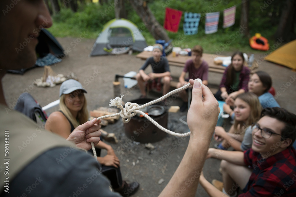 Male teacher showing teaching teenage outdoor school students how to ...