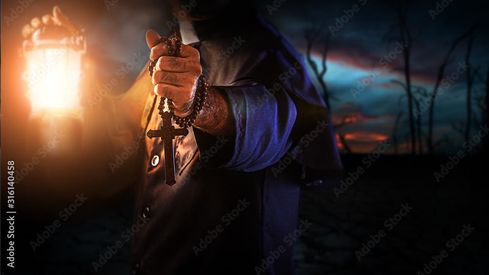 The priest holds the cross on black background For Halloween concepts ...