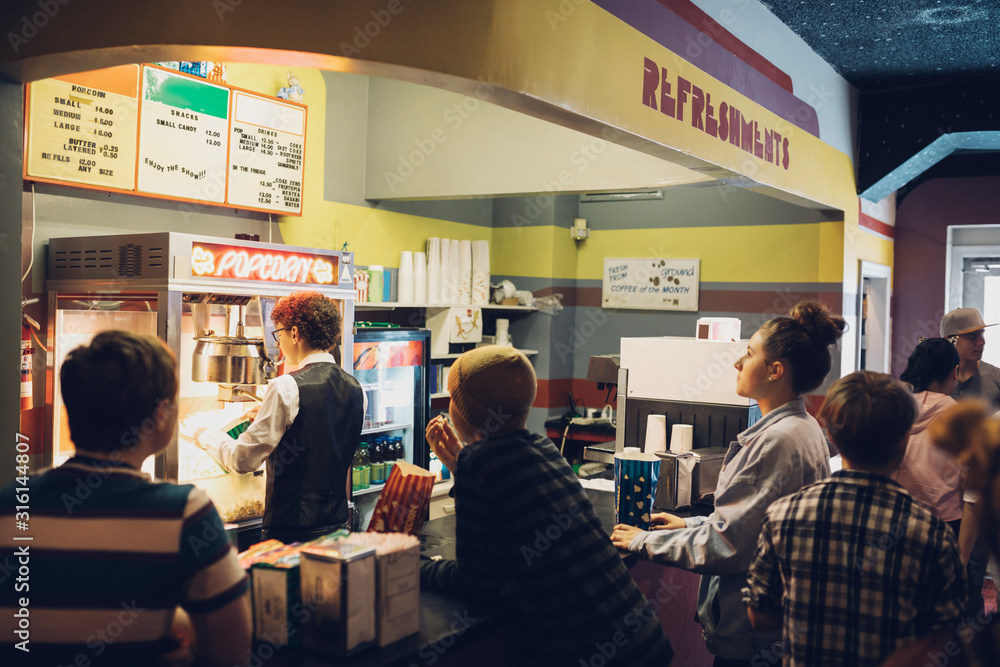 Foto de Tween friends at refreshment concession stand in movie theater ...